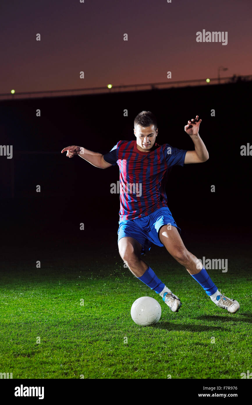 soccer player doing kick with ball on football stadium field isolated ...