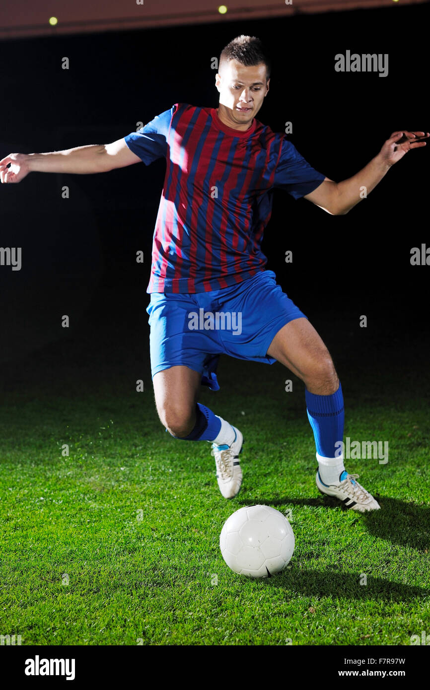 soccer player doing kick with ball on football stadium field isolated ...