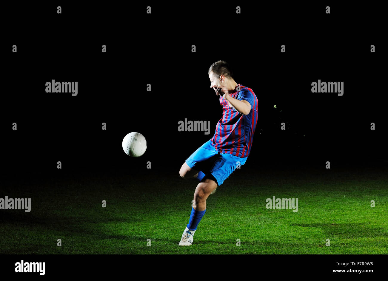 soccer player doing kick with ball on football stadium field isolated ...