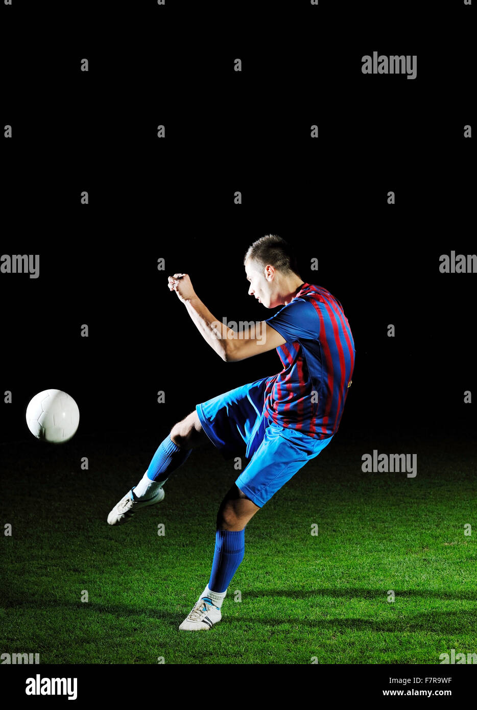 soccer player doing kick with ball on football stadium field isolated ...