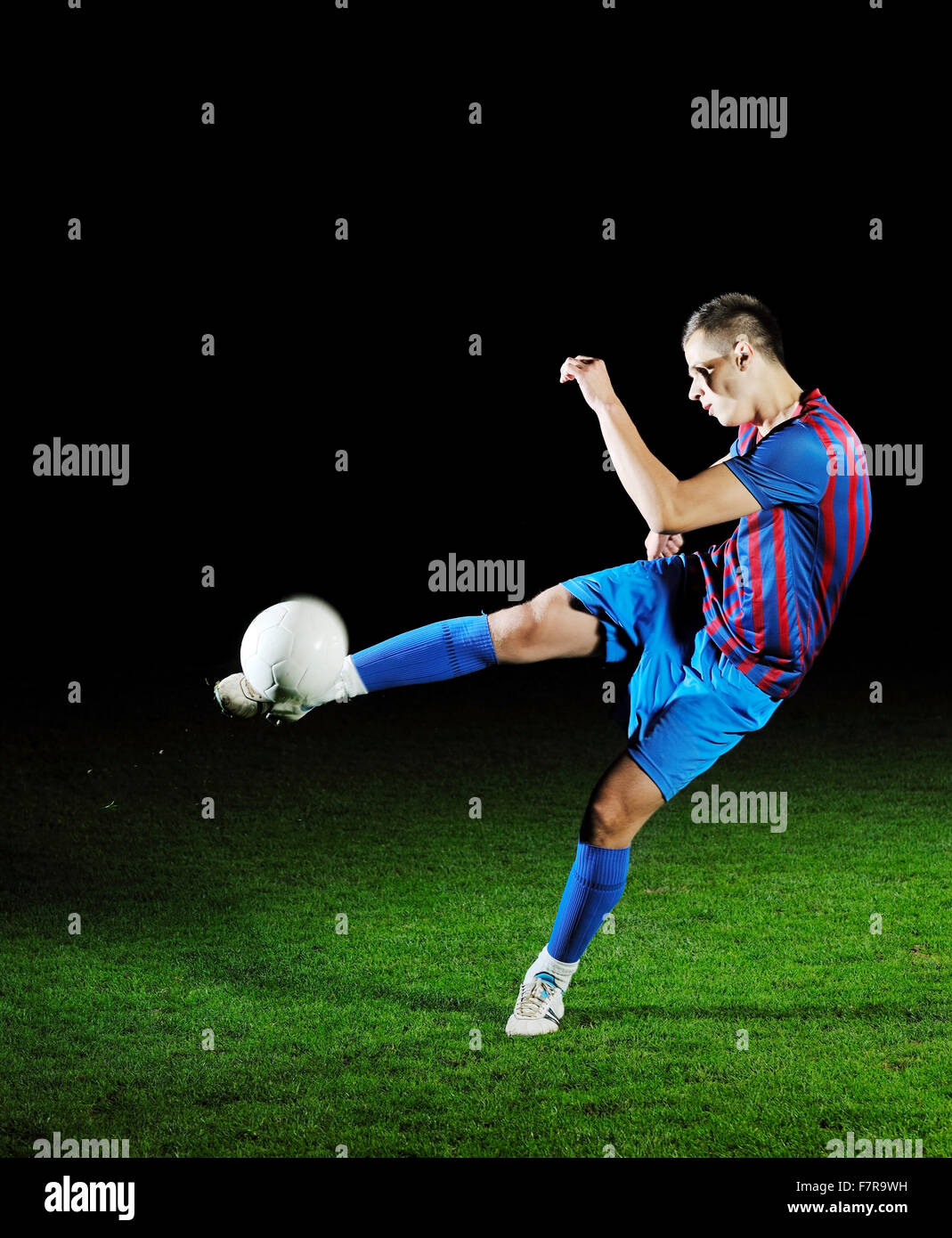 soccer player doing kick with ball on football stadium field isolated ...