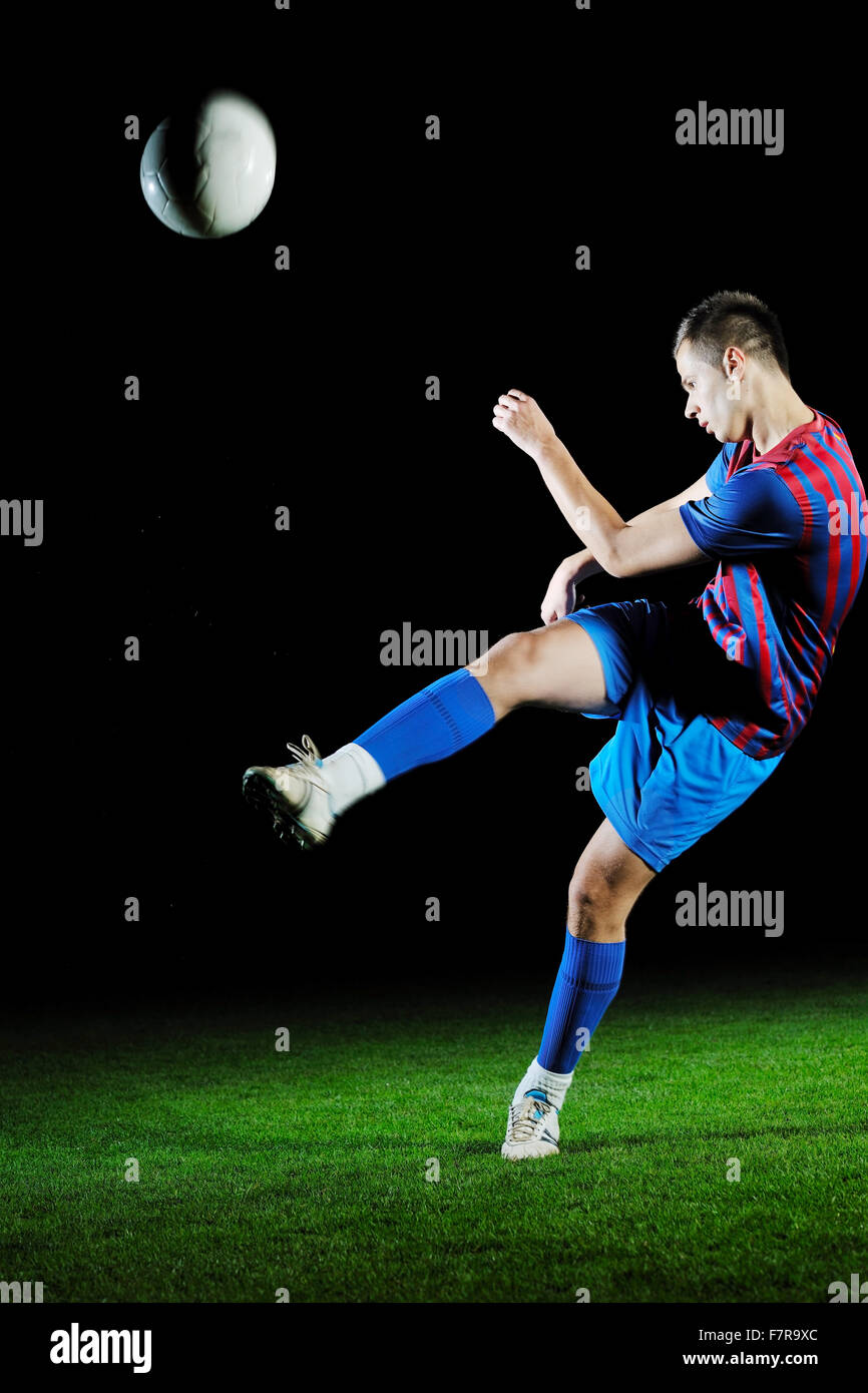 soccer player doing kick with ball on football stadium field isolated ...