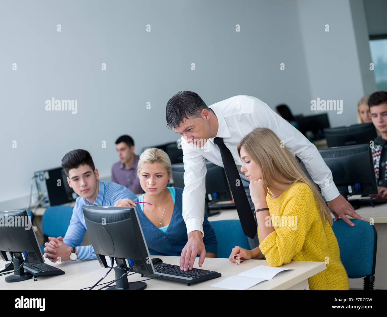 group of students with teacher in computer lab classrom learrning ...
