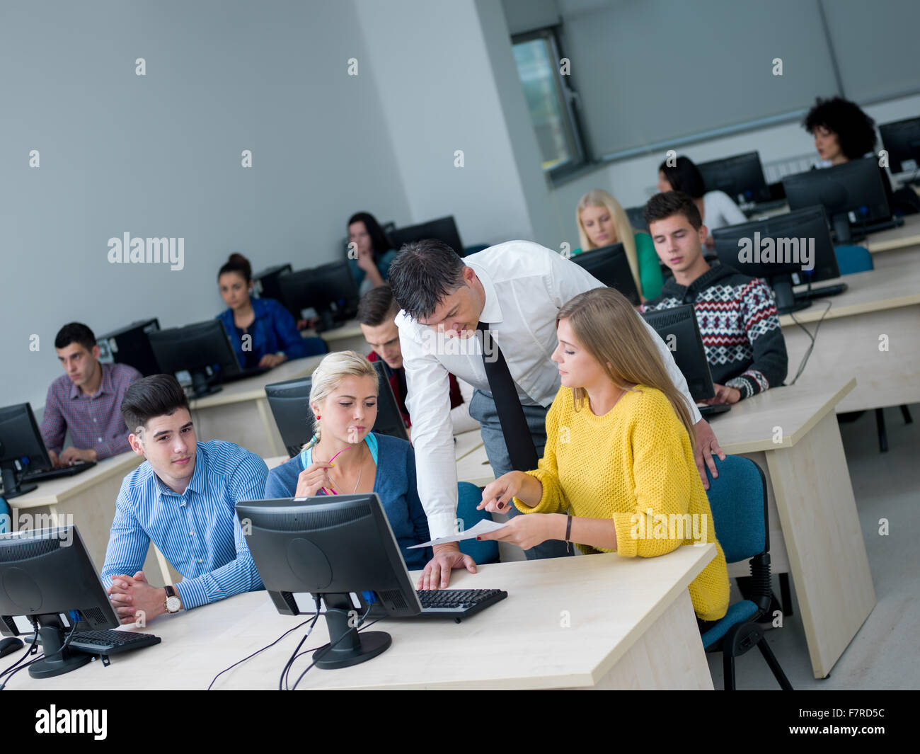 group of students with teacher in computer lab classrom learrning ...