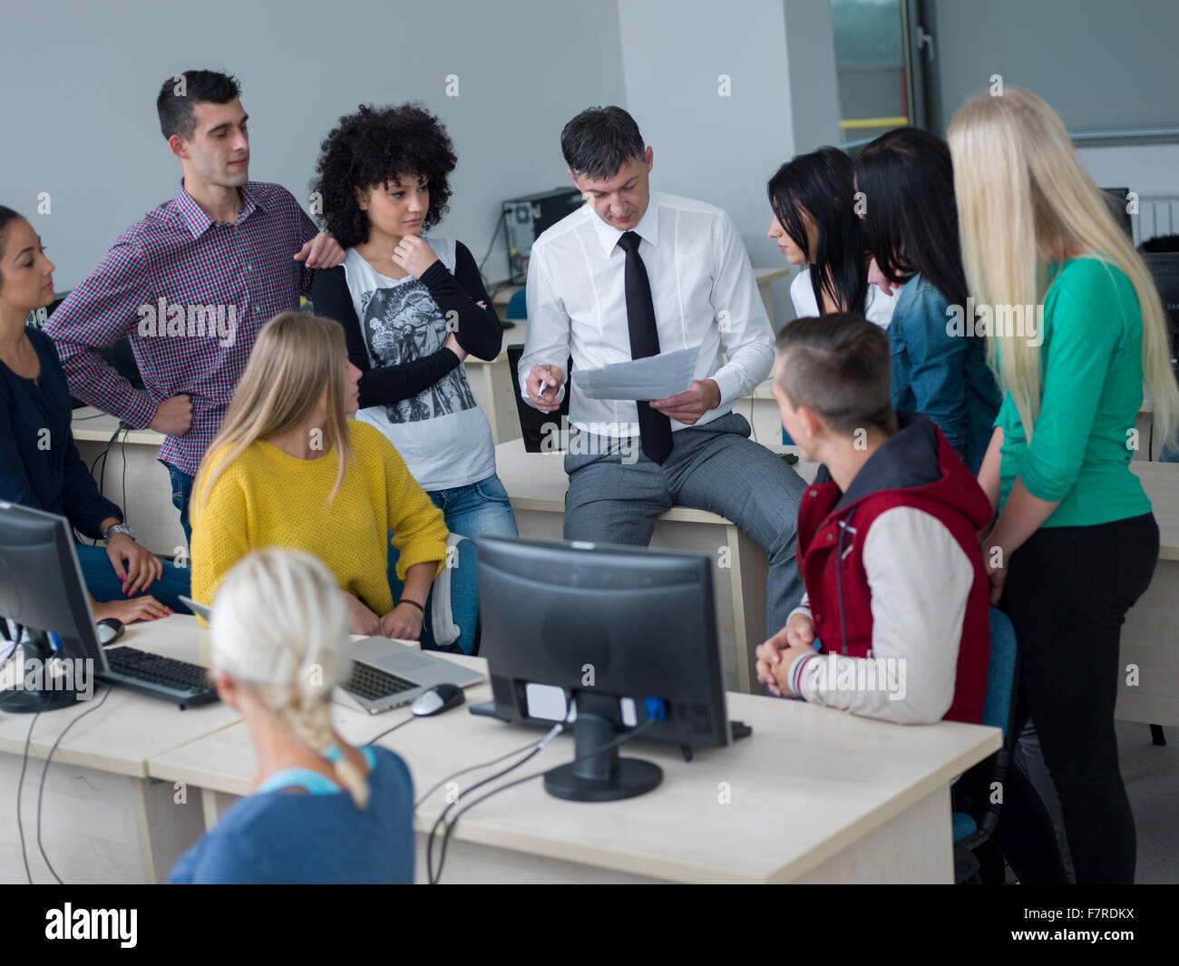 group of students with teacher in computer lab classrom learrning ...