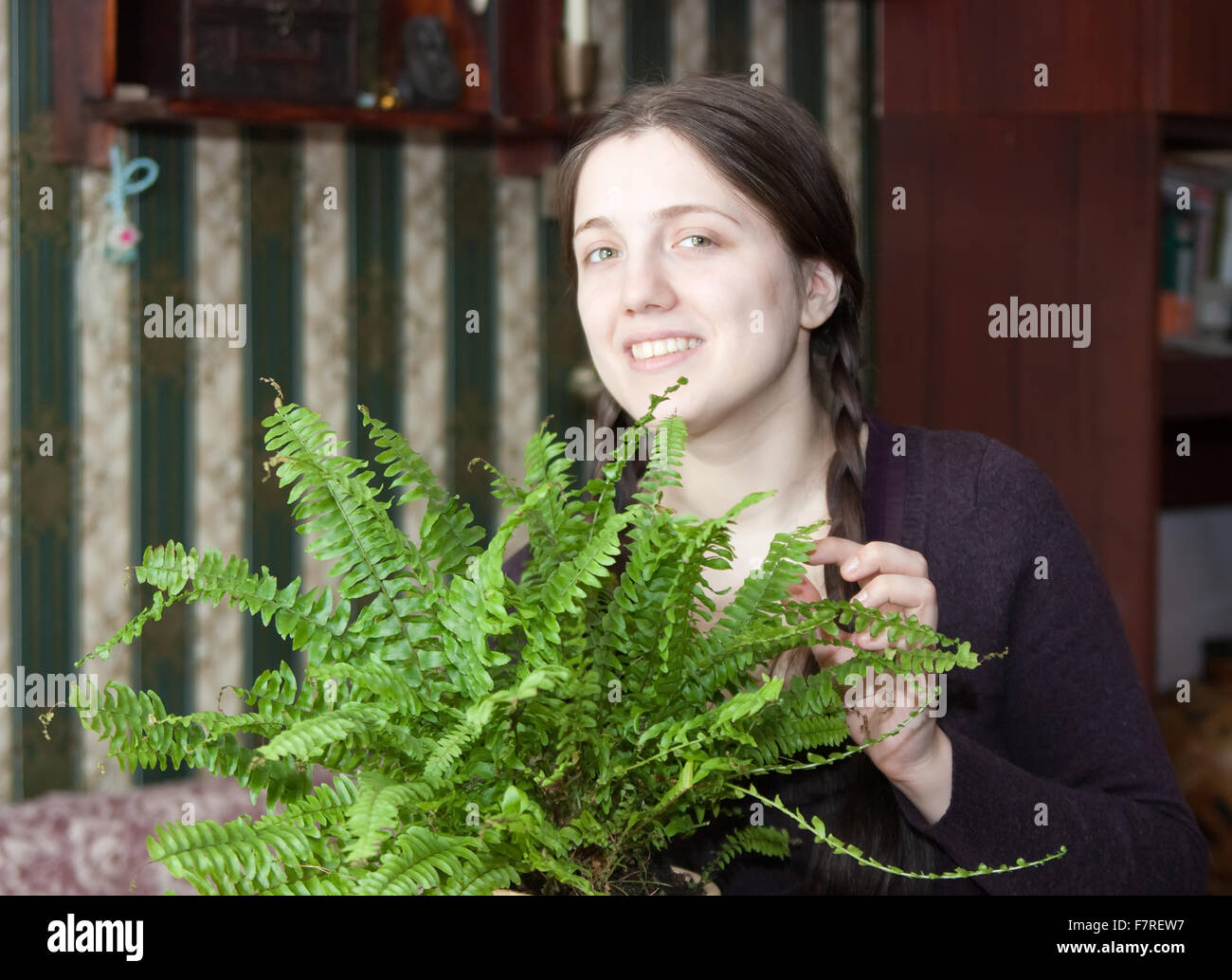 Attractive woman with fern flower in the pot at her home Stock Photo ...