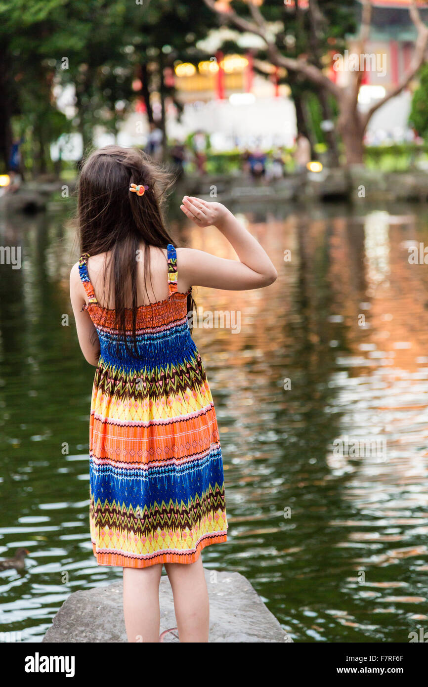 Young girl in colorful dress by lake Stock Photo - Alamy