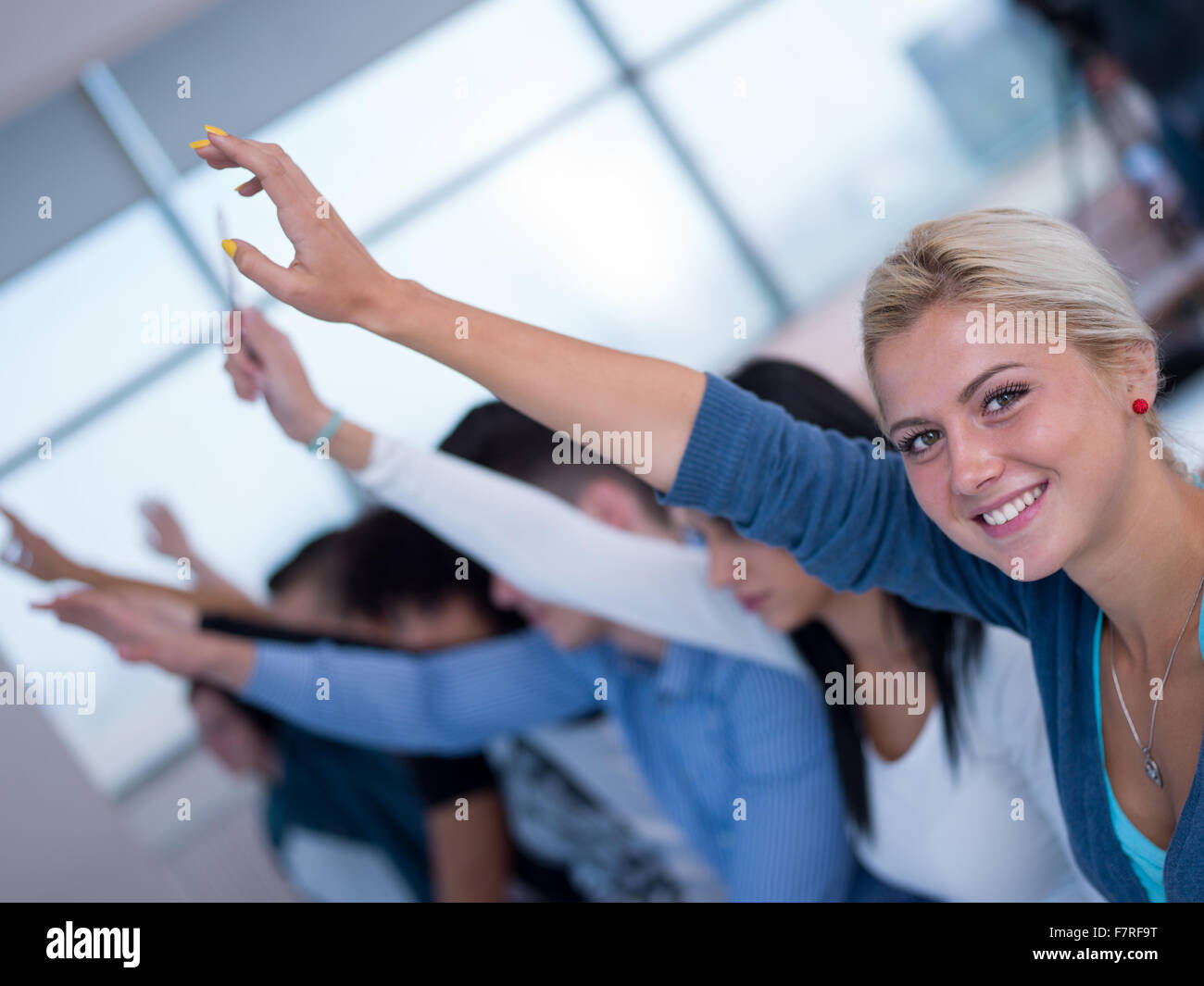 Group Of Students Arms Up In Classroom High Resolution Stock ...