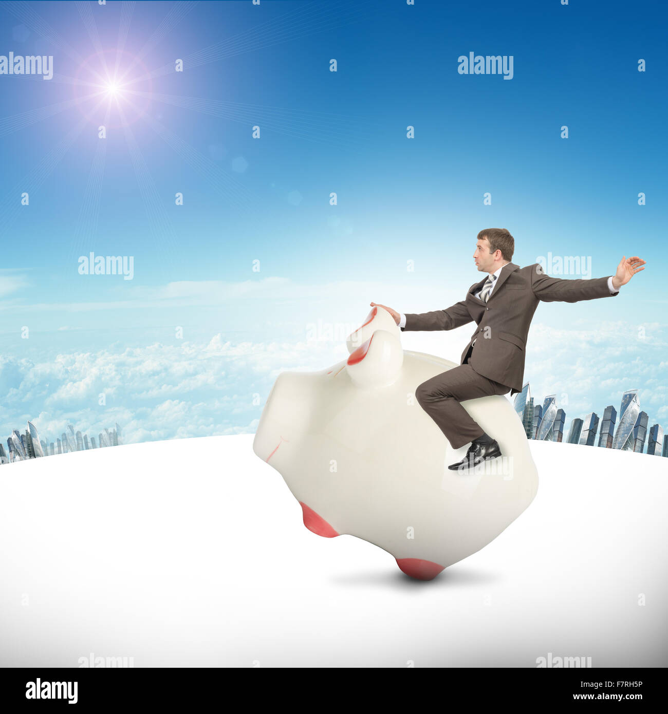 Man sitting on white piggy bank, side view Stock Photo - Alamy