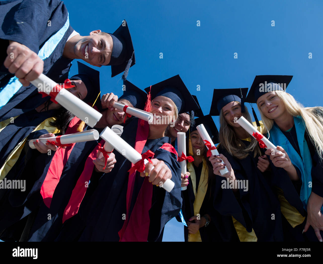high school students graduates tossing up hats over blue sky Stock ...