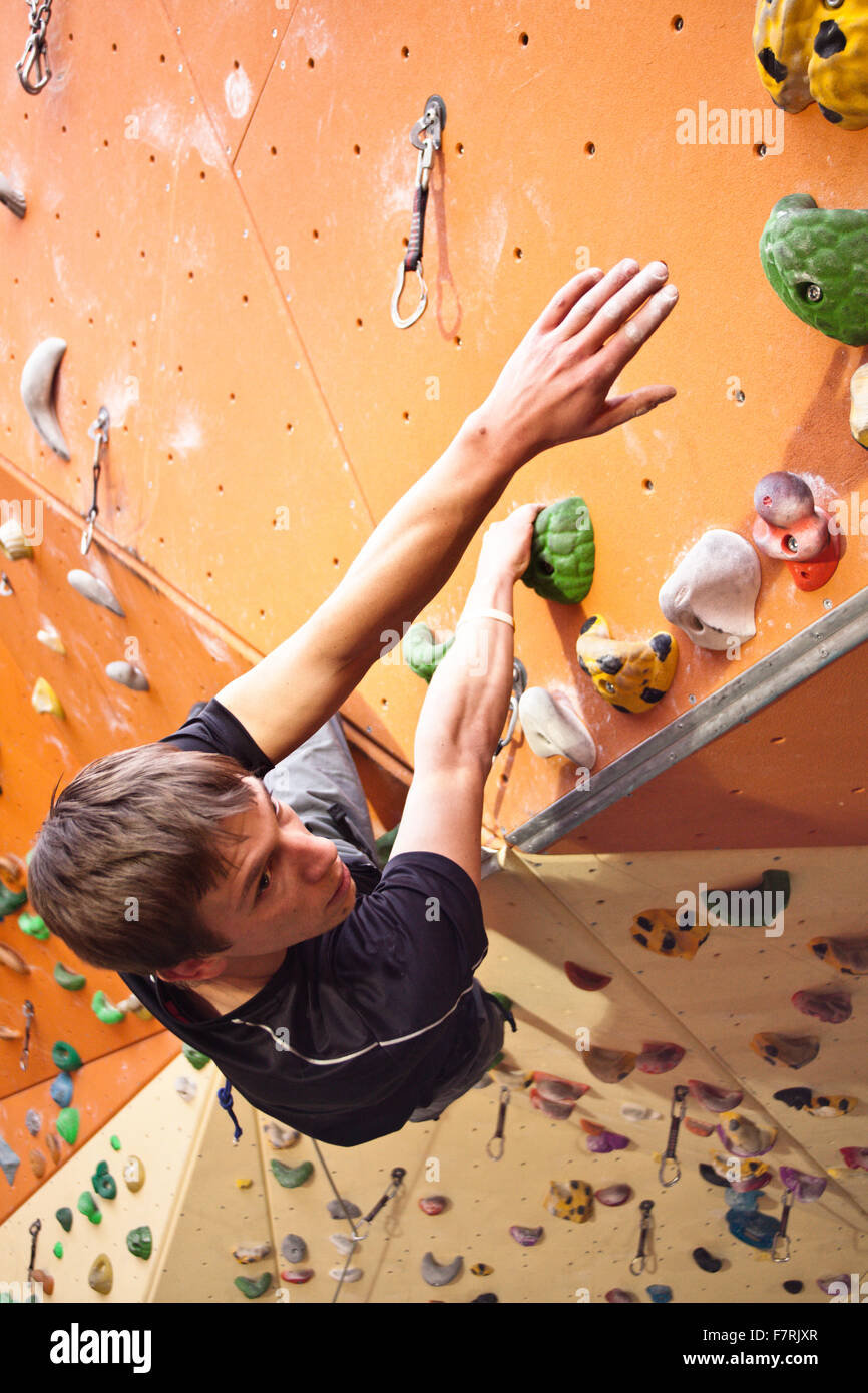 climber in an indoor climbing hall, about to reach the next hold Stock ...