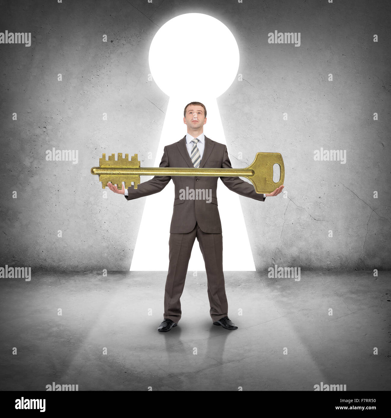 Businessman holding huge gold key Stock Photo - Alamy