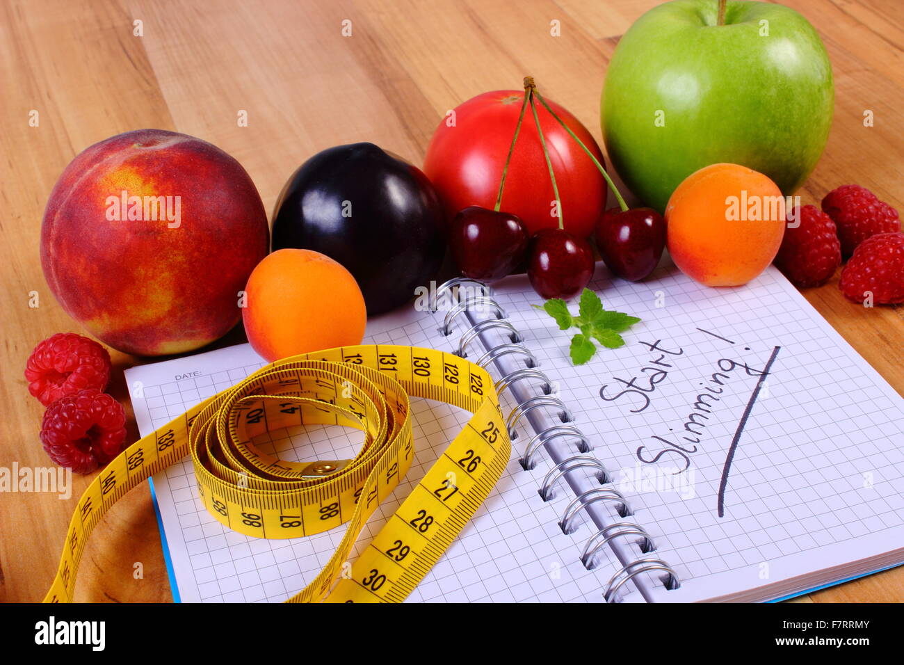 Fresh fruits and vegetables with tape measure and notebook for writing ...
