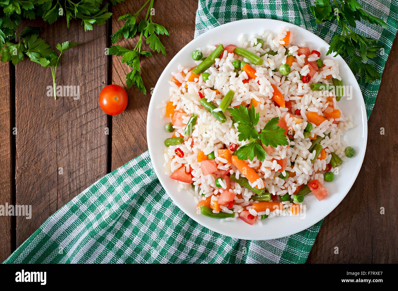 Appetizing healthy rice with vegetables in white plate on a wooden ...