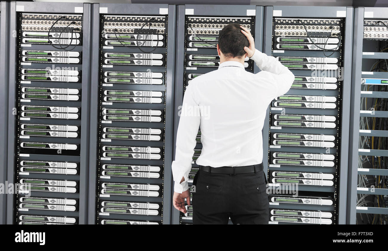 it business man in network server room have problems and looking for ...