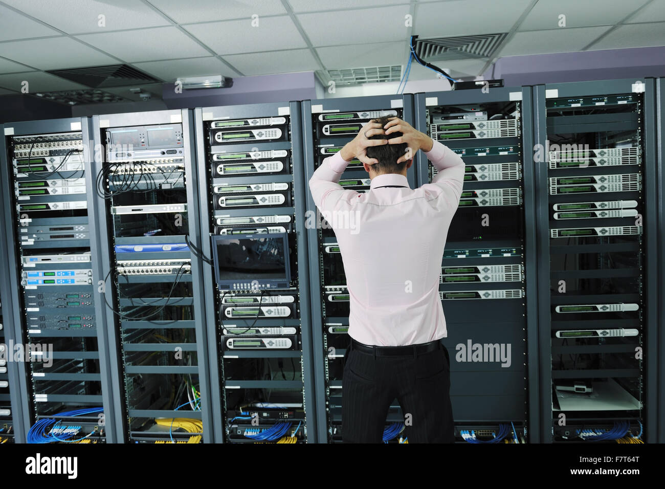 it business man in network server room have problems and looking for ...