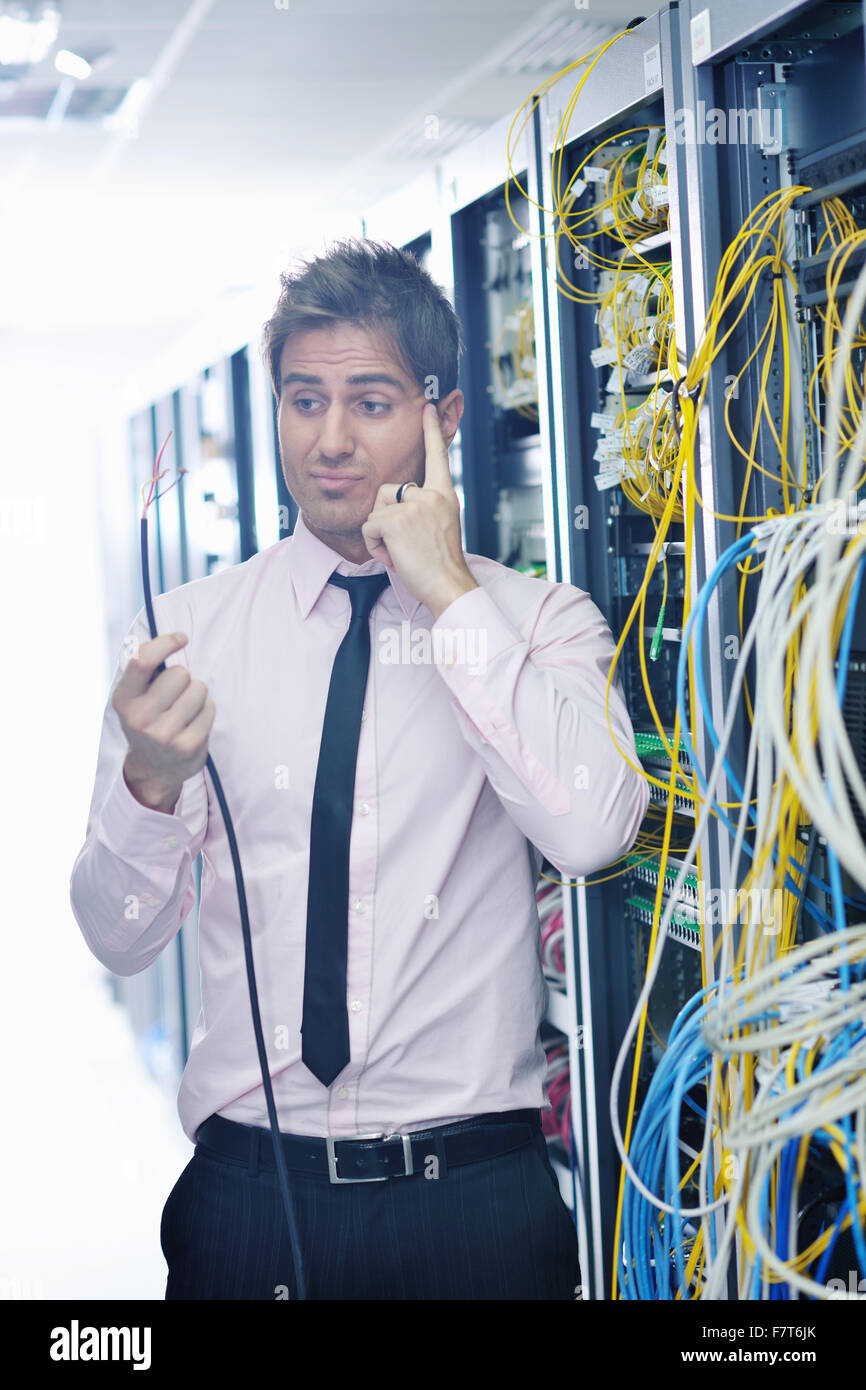 it business man in network server room have problems and looking for ...