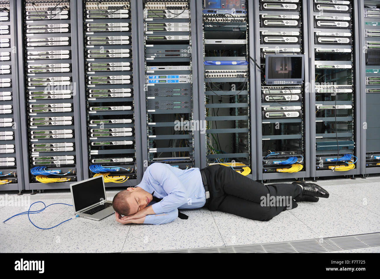it business man in network server room have problems and looking for ...