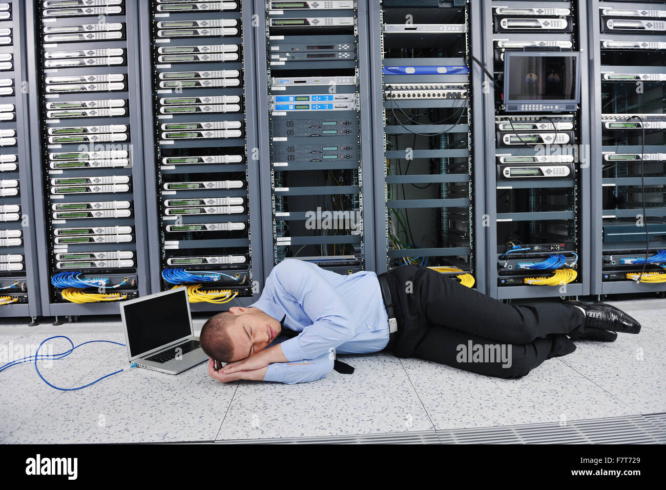 it business man in network server room have problems and looking for ...
