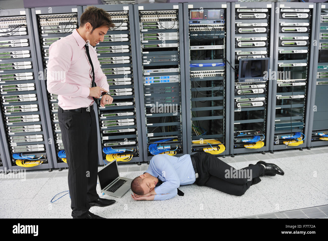 it business man in network server room have problems and looking for ...