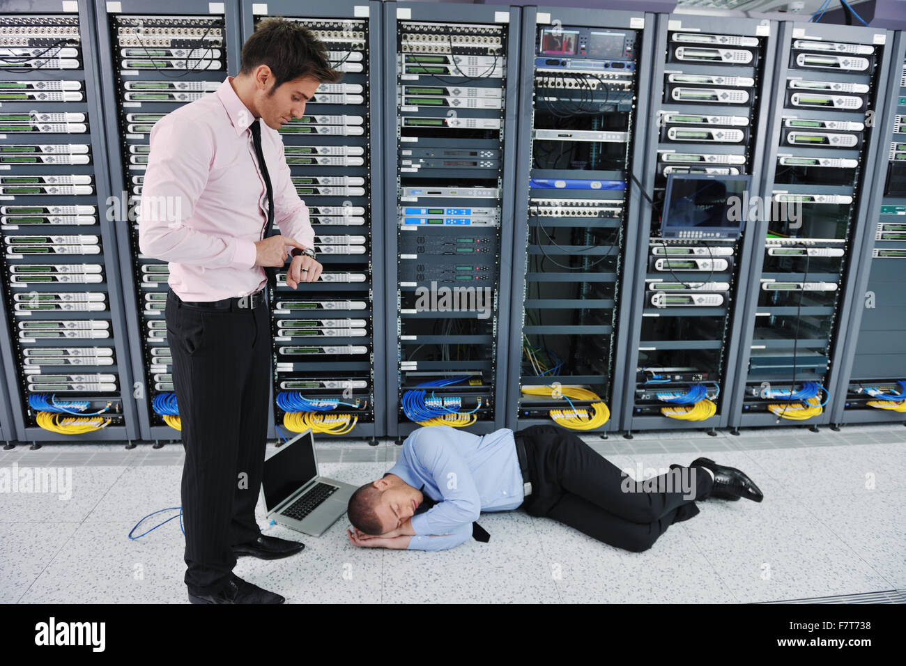 it business man in network server room have problems and looking for ...