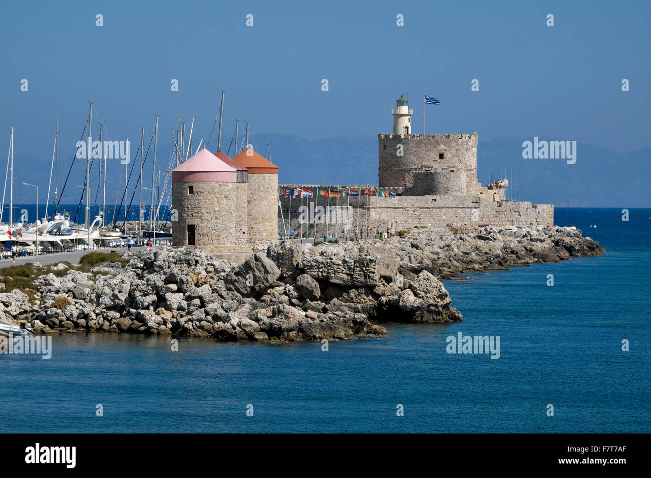 Windmills and Ágios Nikólaos fortress at Mandrake harbor, with ...