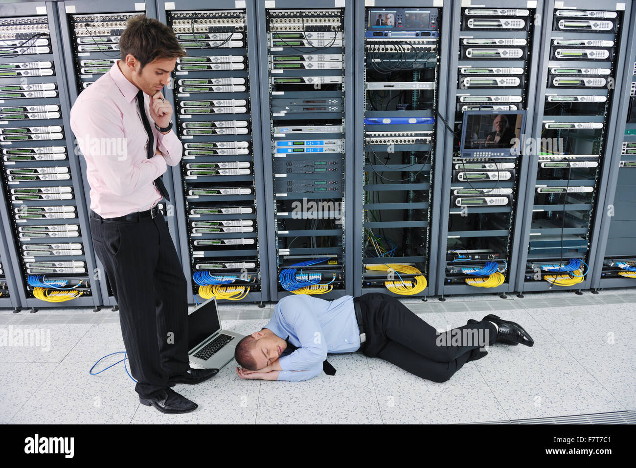 it business man in network server room have problems and looking for ...