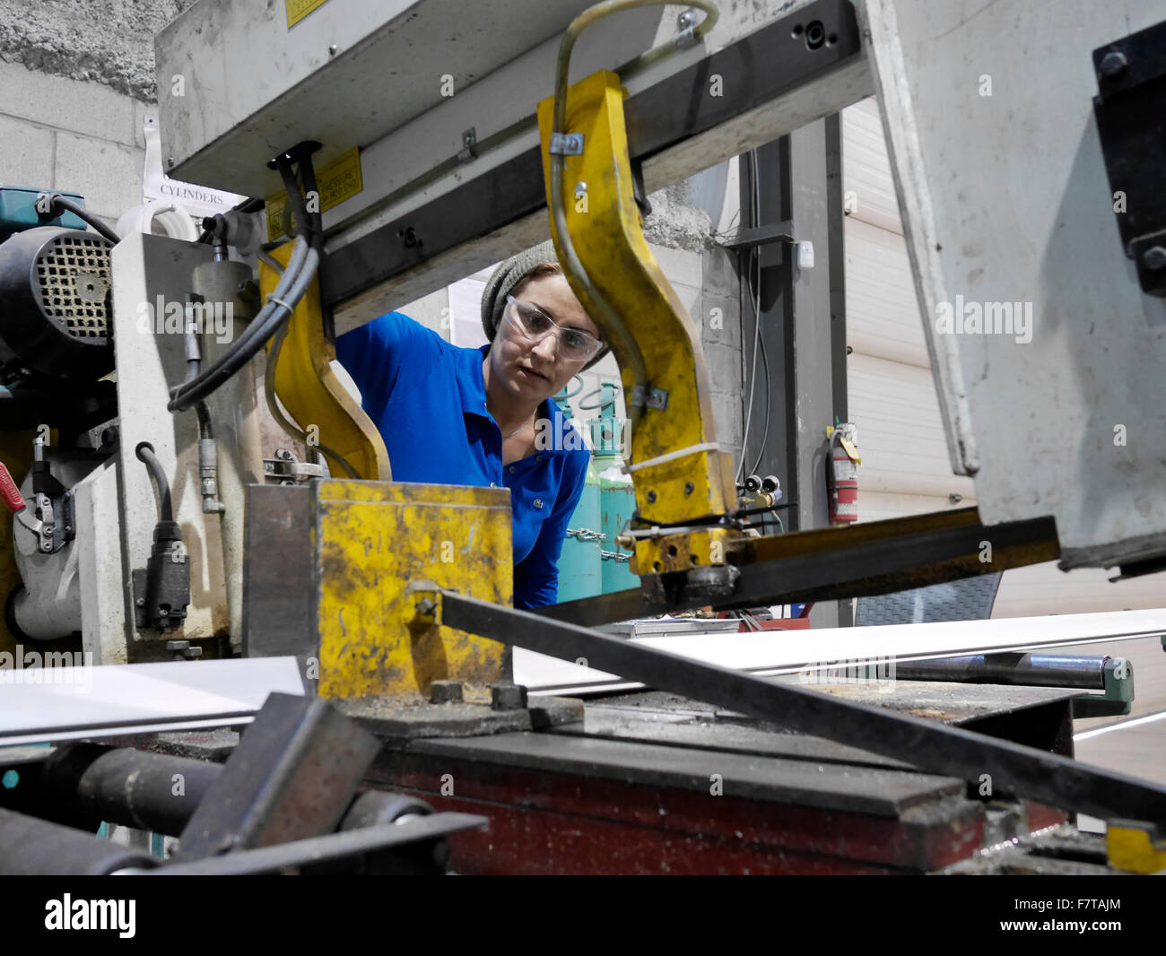 Female worker fine tuning machine for cutting a metal angle Stock Photo ...