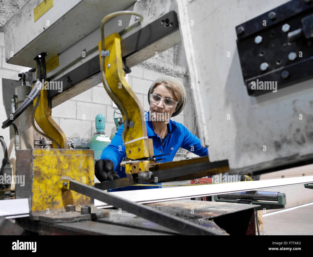 Female worker fine tuning machine for cutting a metal angle Stock Photo ...