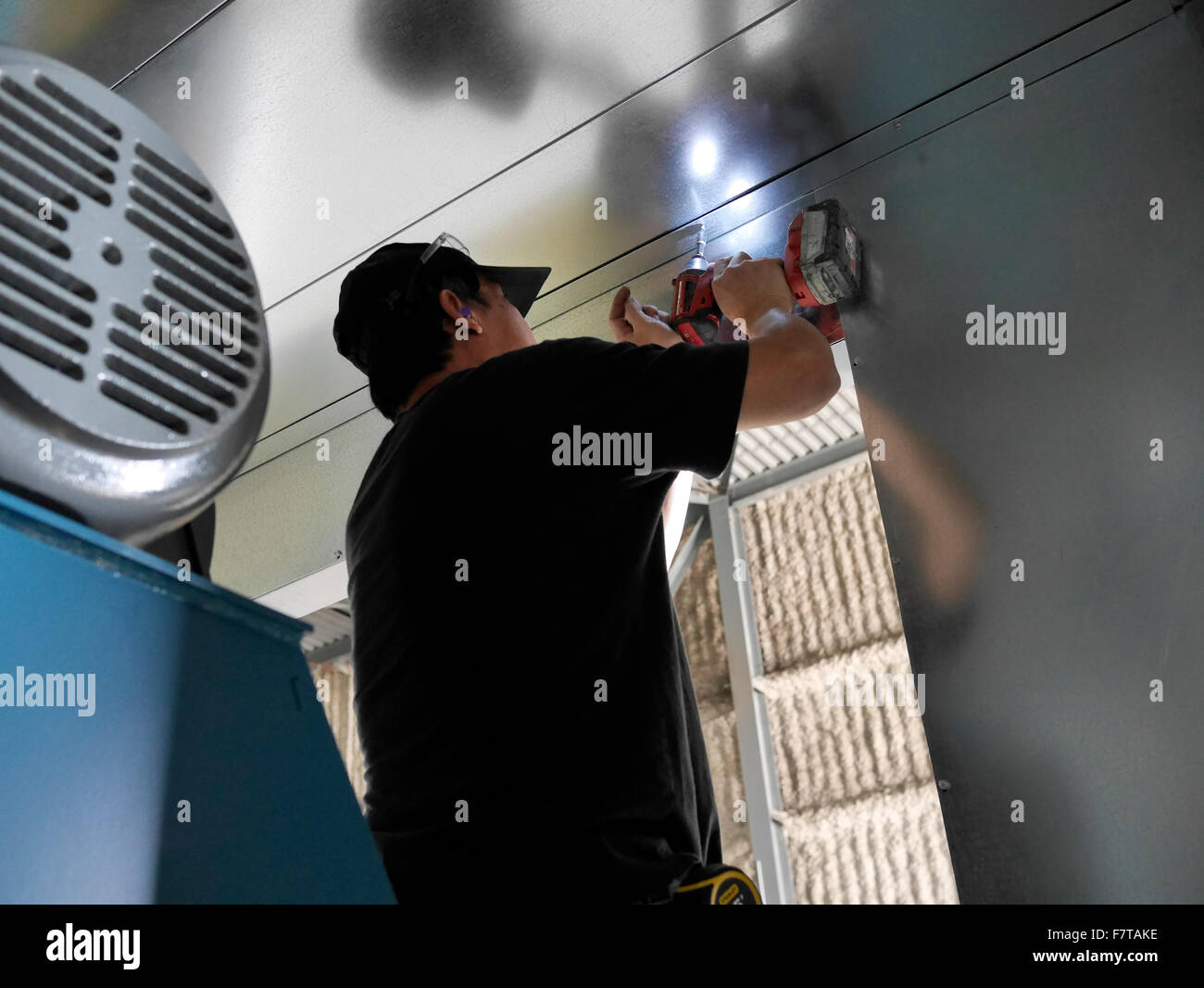 Worker assembling an industrial HVAC (heating, ventilating, and air ...