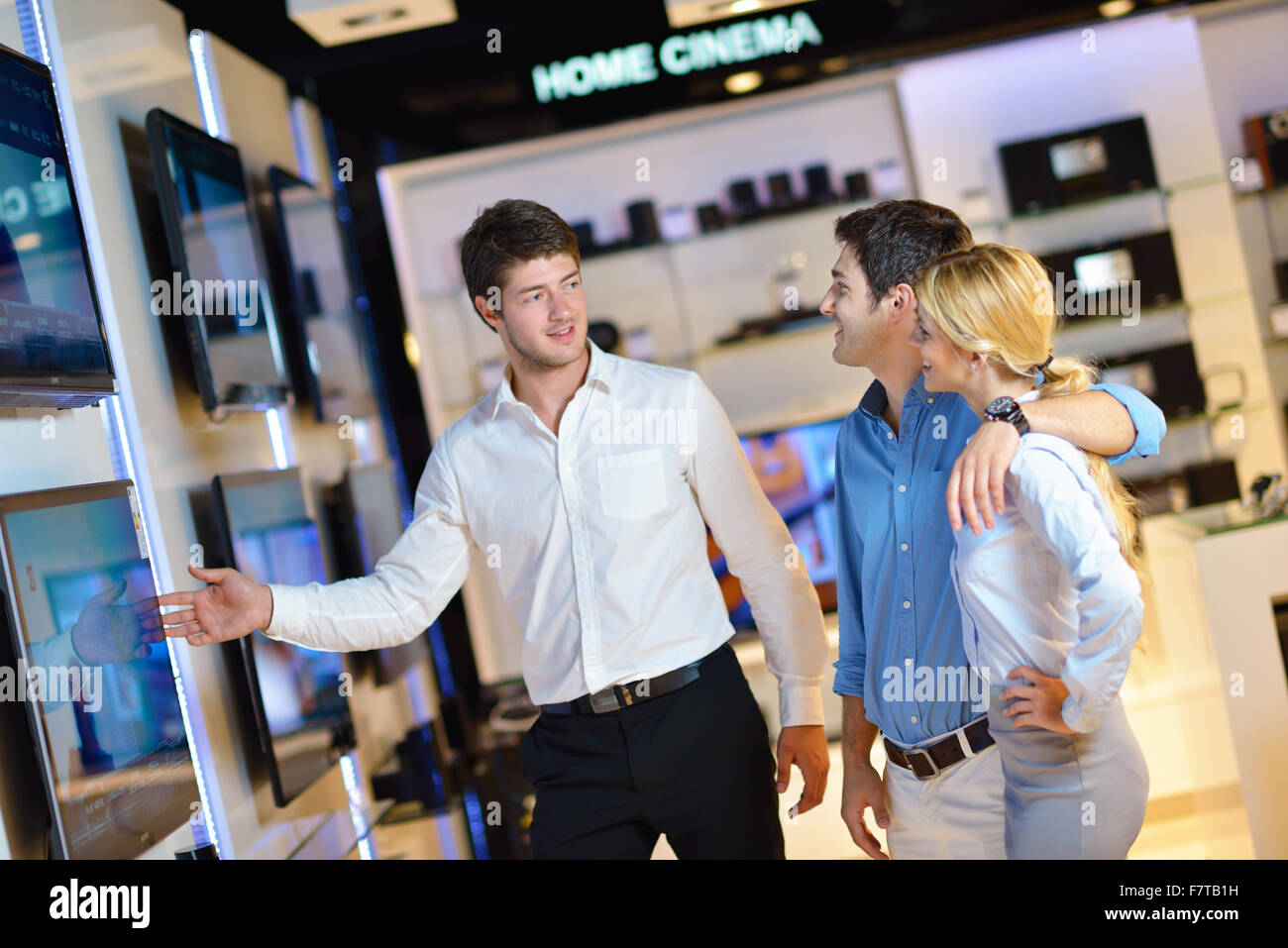 Young couple in consumer electronics store looking at latest laptop ...