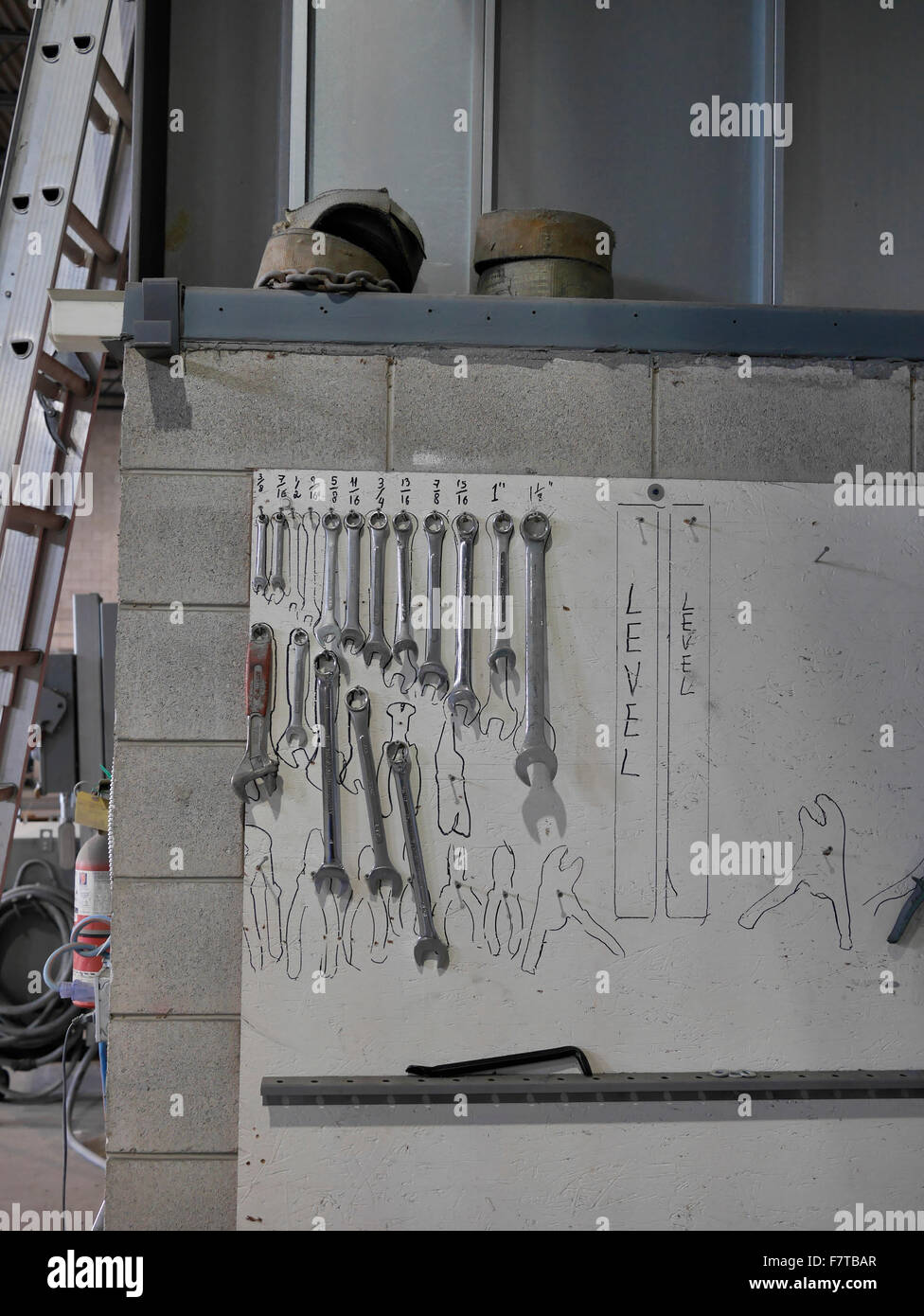 Tools hung on factory walls with tool outline on walls Stock Photo - Alamy
