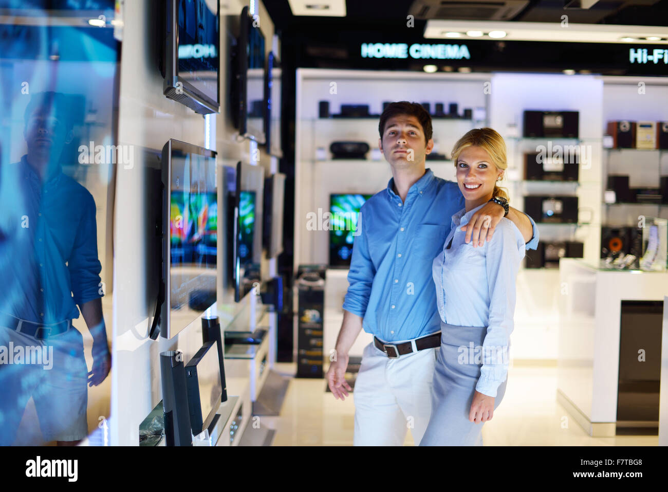 Young couple in consumer electronics store looking at latest laptop ...