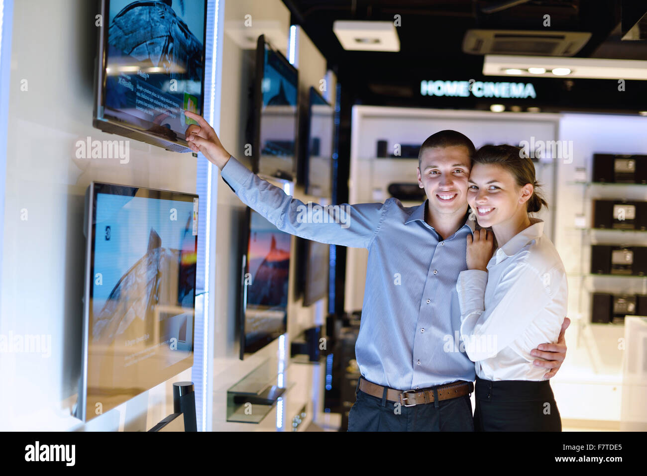 Young couple in consumer electronics store looking at latest laptop ...