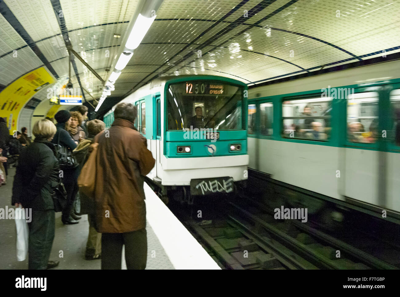 France, Paris, Metro train arriving in a station with people waiting on ...