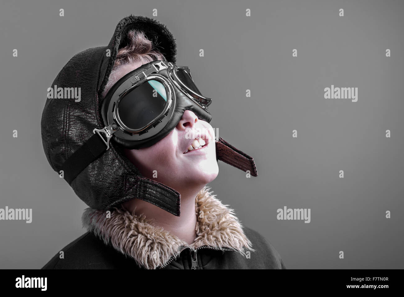 happy child playing the aircraft pilot with hat and retro bomber jacket ...