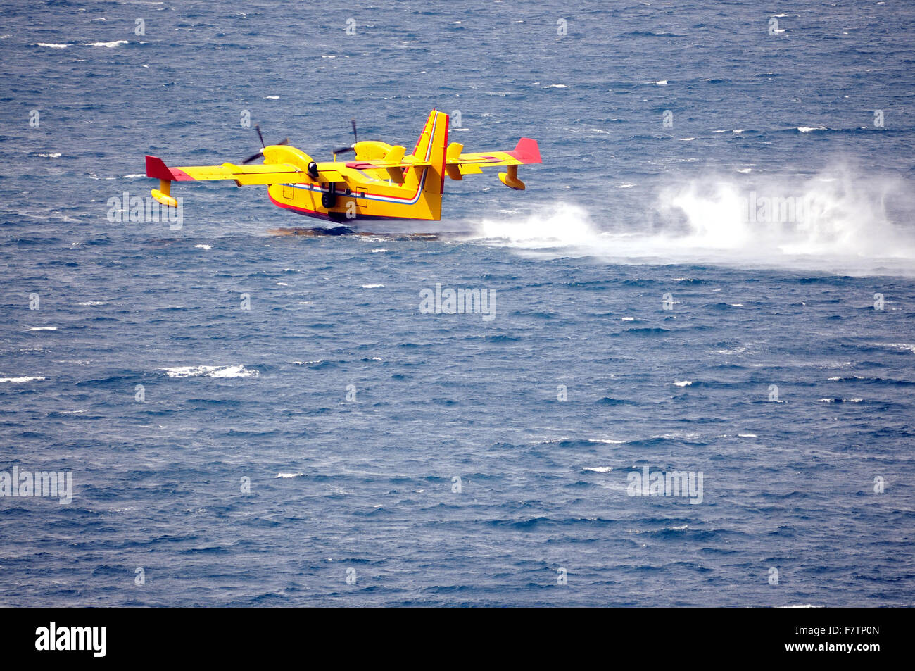 Airplane on sea taking water to drop over fire Stock Photo - Alamy