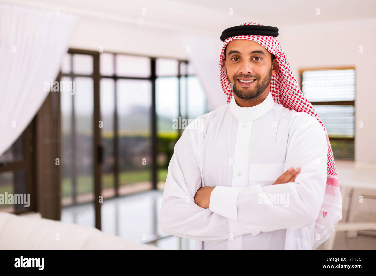 portrait of happy Arabian man standing indoors Stock Photo - Alamy