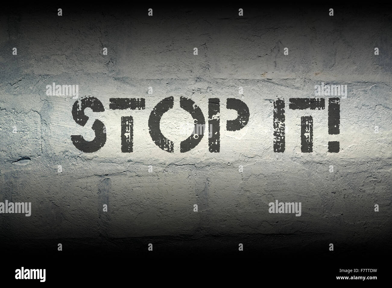 stop it stencil print on the grunge white brick wall Stock Photo - Alamy