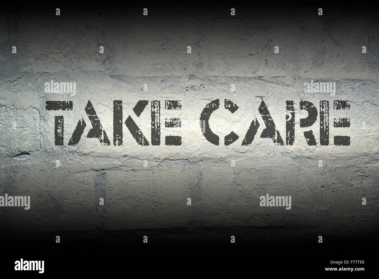 take care stencil print on the grunge white brick wall Stock Photo - Alamy