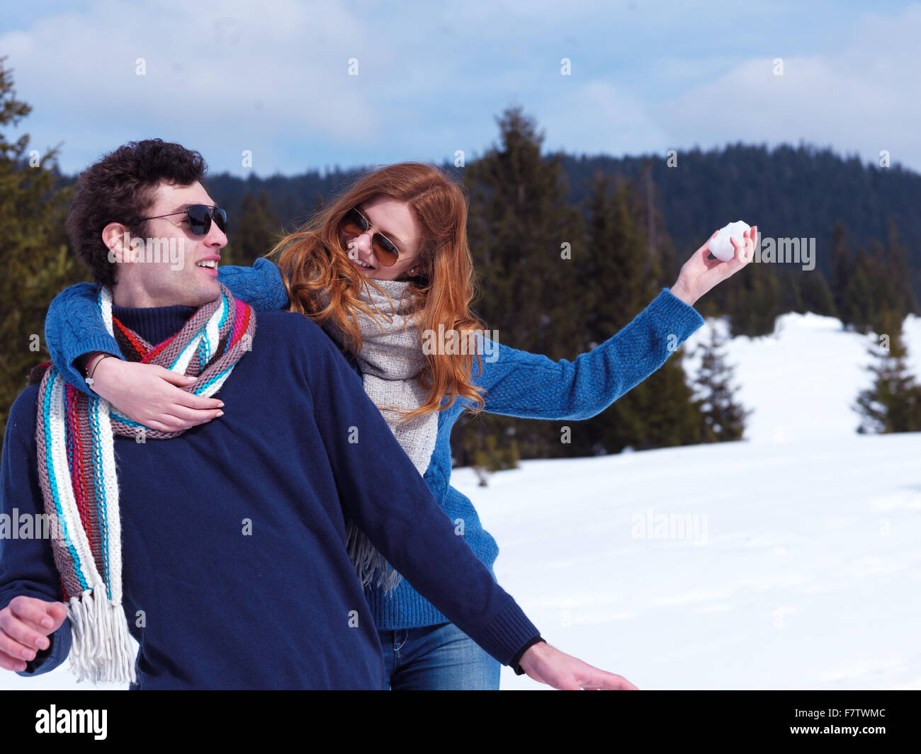 romantic winter scene, happy young couple having fun on fresh show on ...