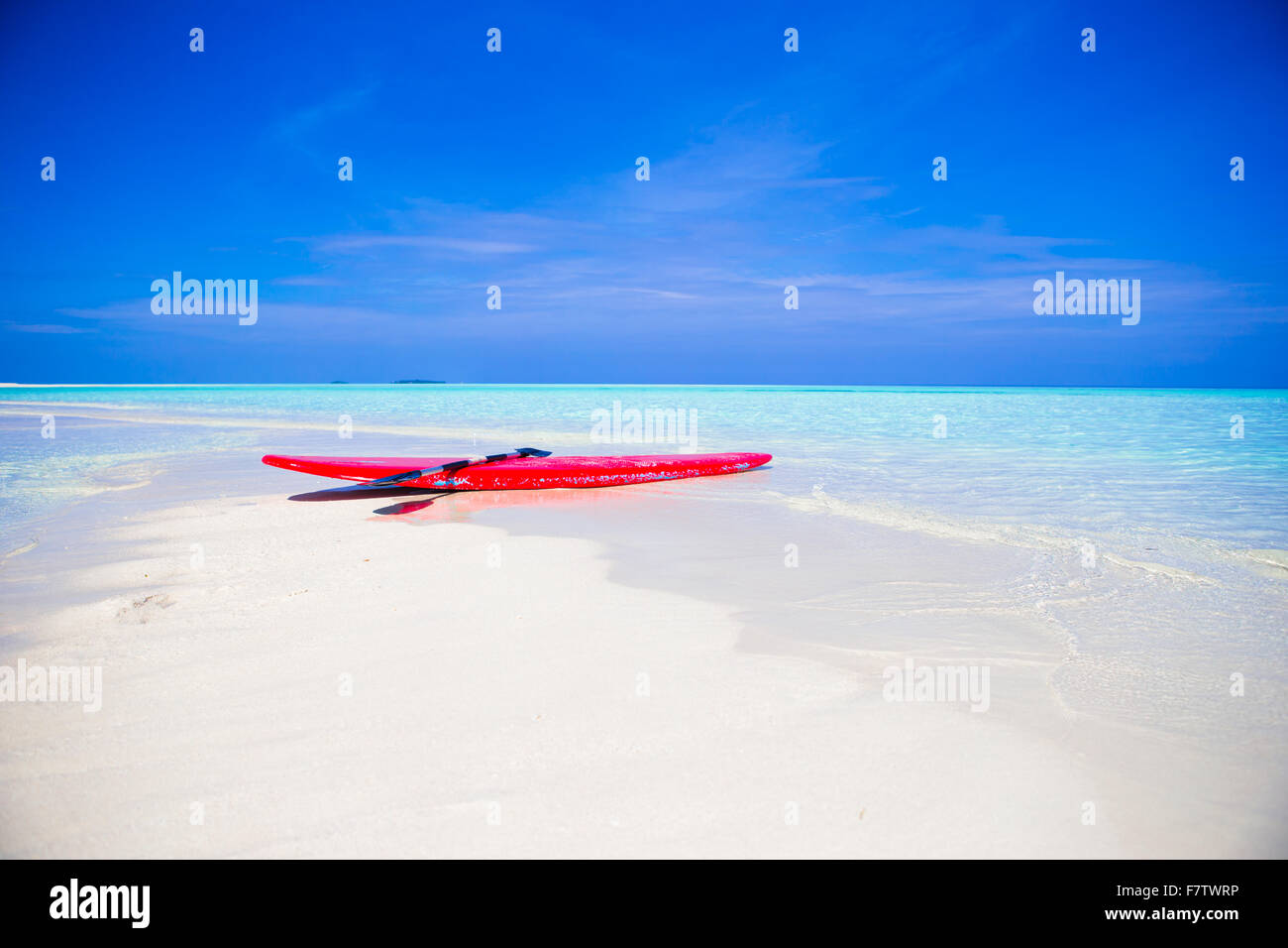 Red surfboard on white sandy beach with turquoise water Stock Photo - Alamy