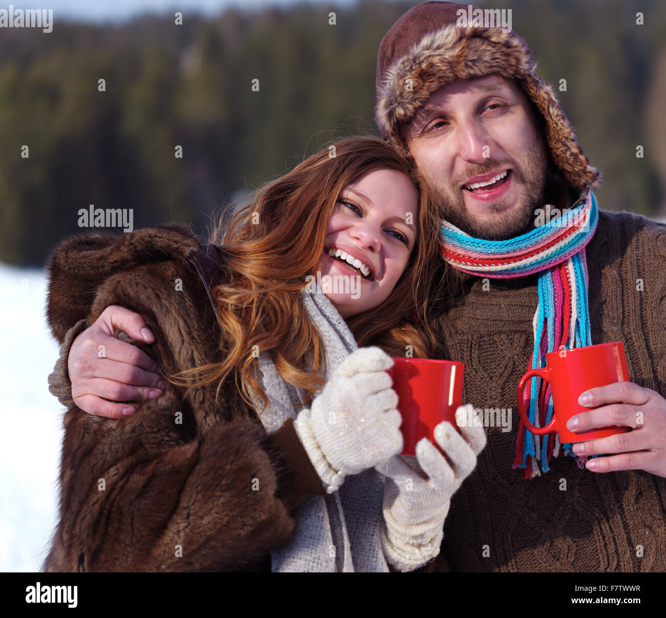 portrait of happy young couple outdoor on winter day drinking warm tea ...