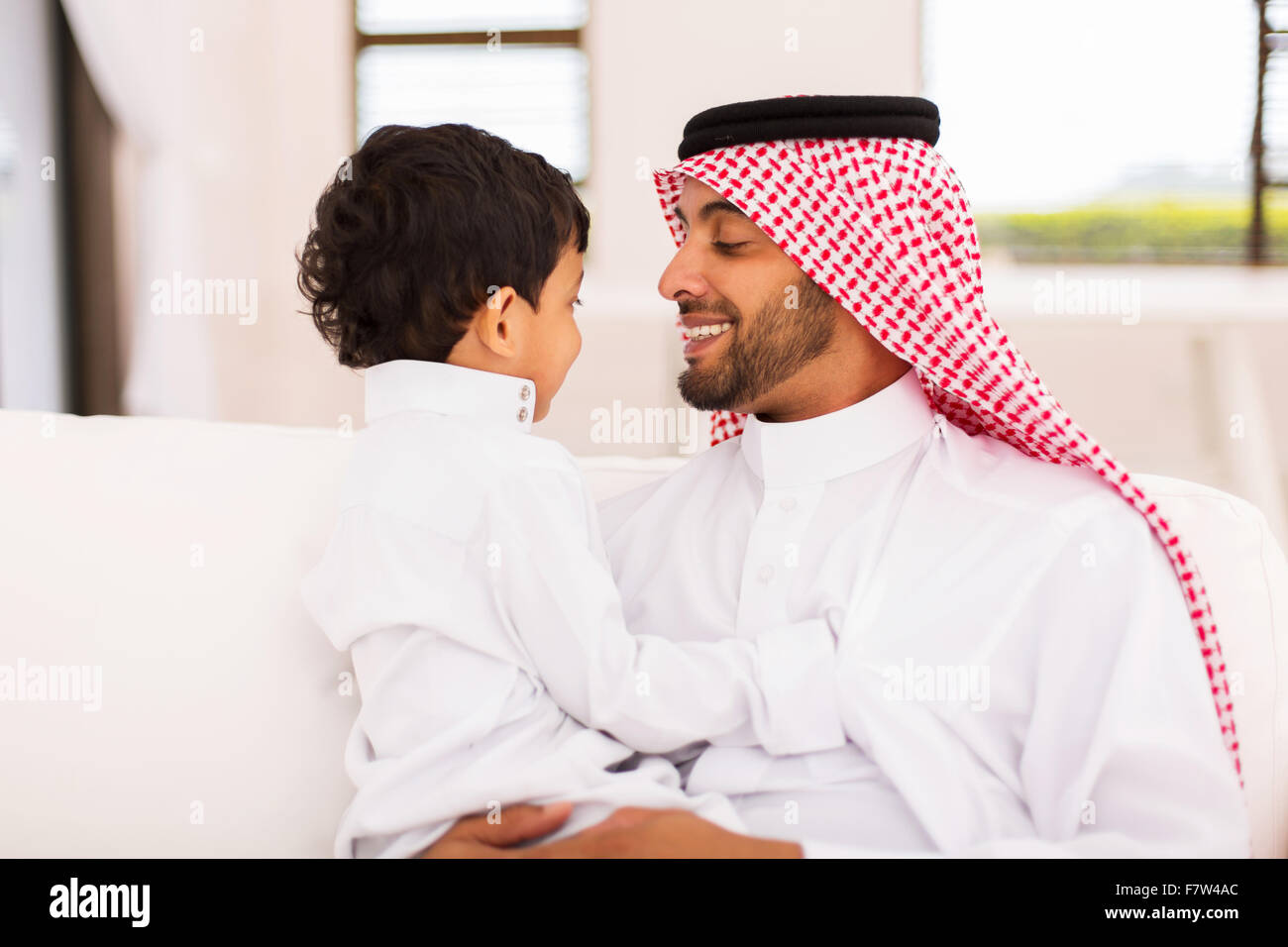 portrait of happy Arabian father and son sitting at home Stock Photo ...