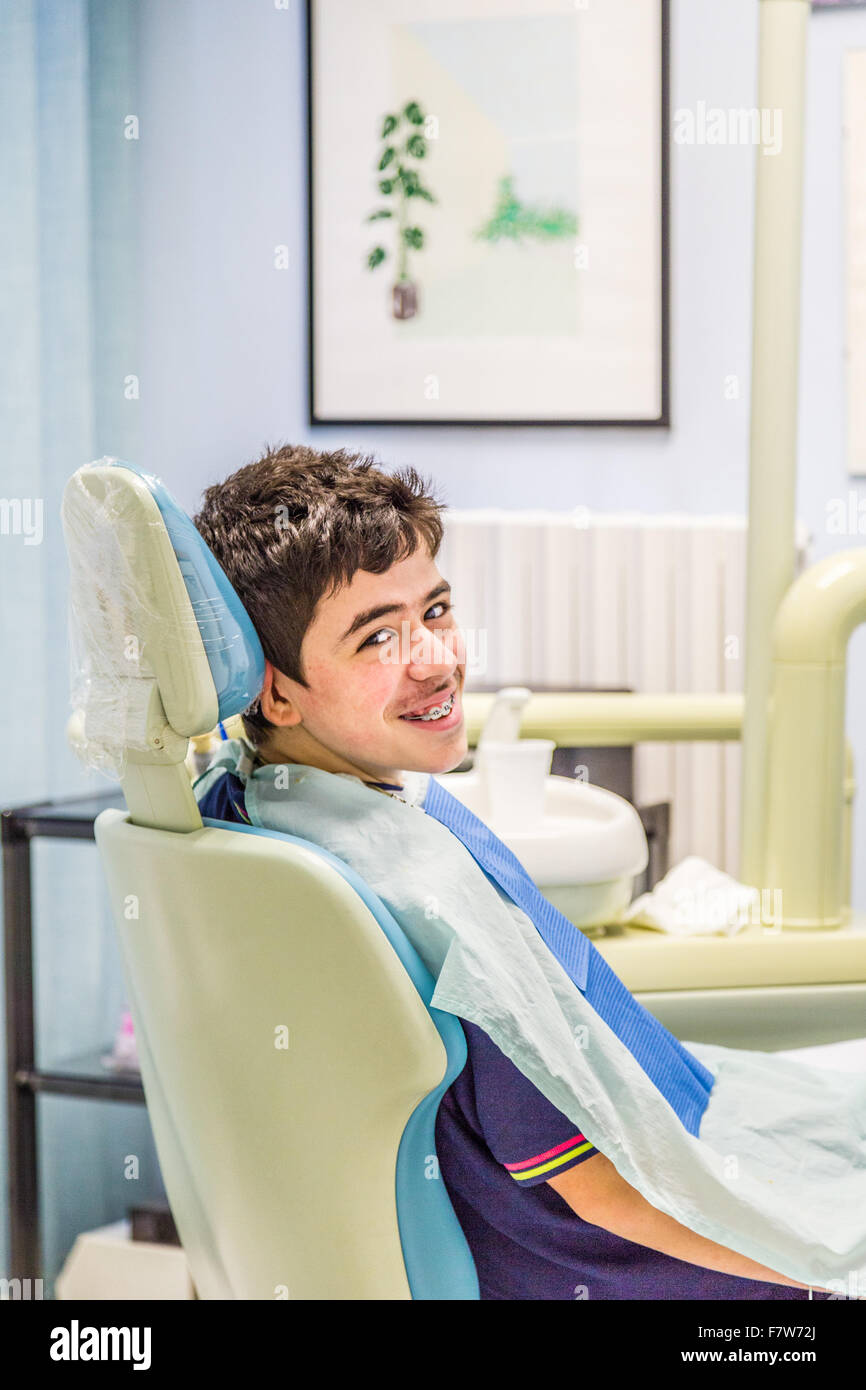 Caucasian teenager with moustache and acne skin sitting on the dentist ...