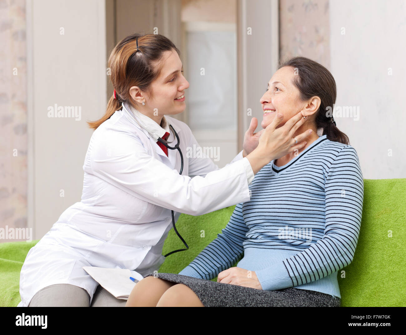 friendly doctor examining mature woman on couch Stock Photo - Alamy