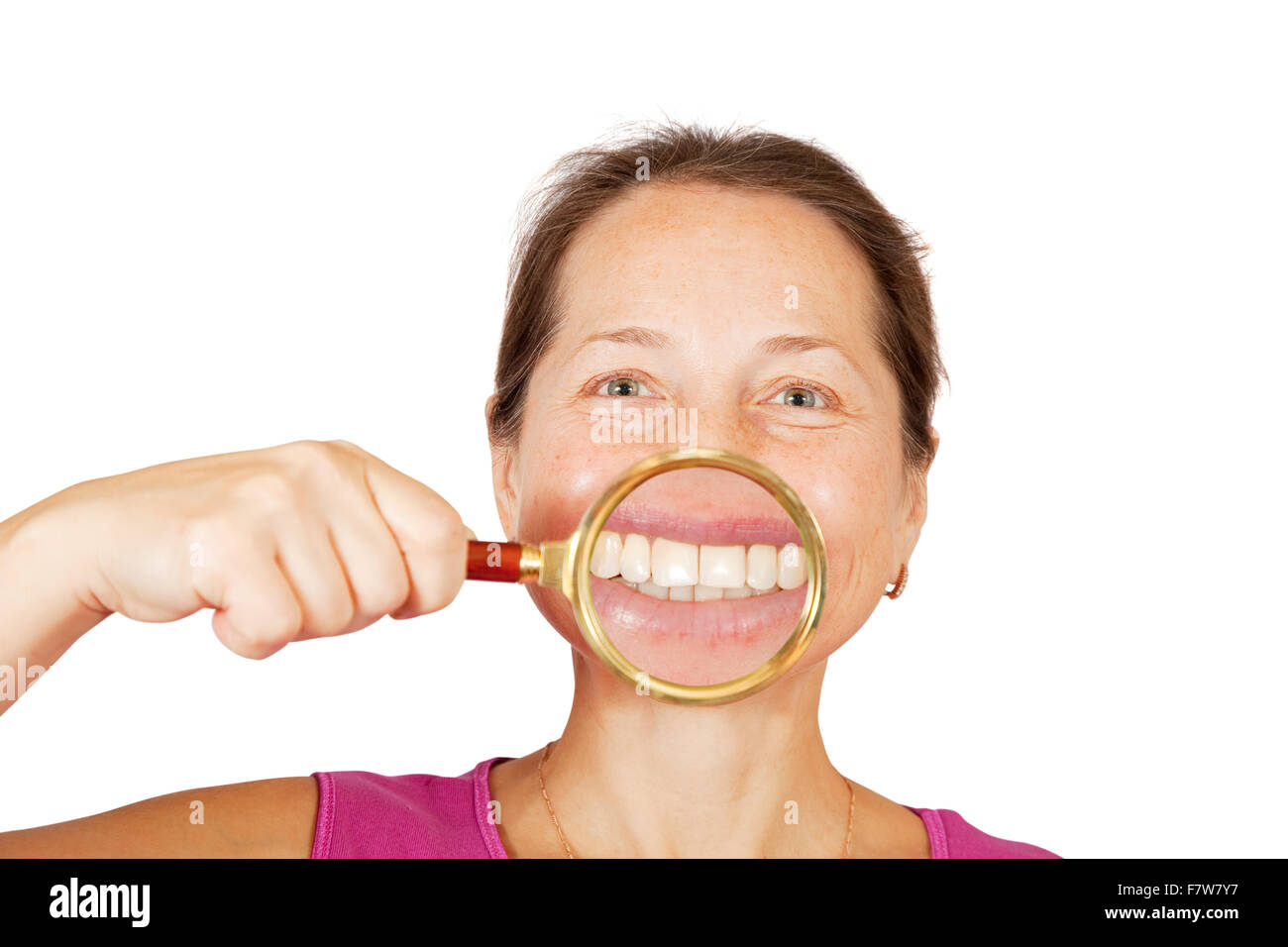 Teeth of mature woman through magnifier, isolated on white background ...