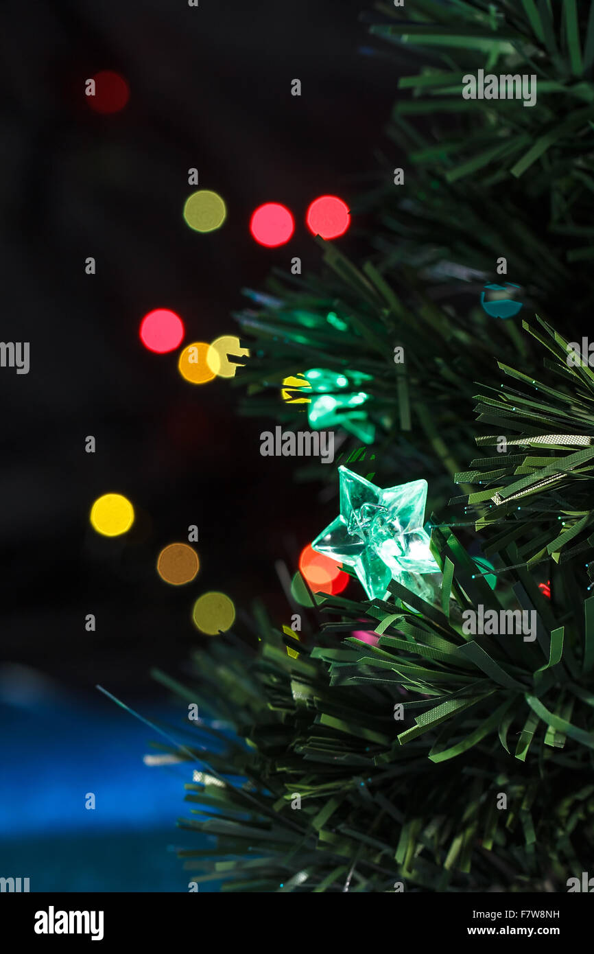 Christmas tree with garland against multicolored defocused lights Stock ...