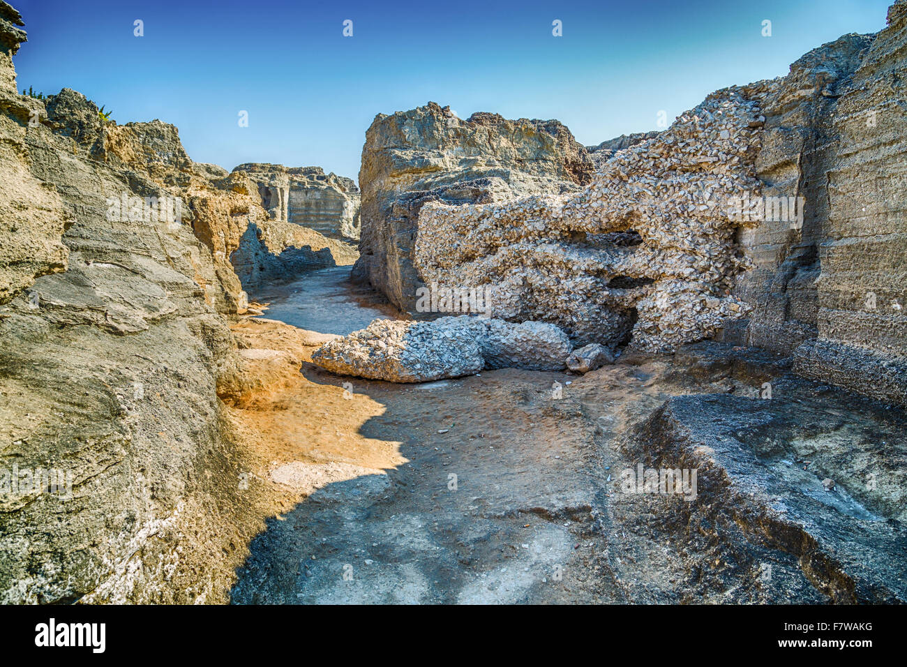 Path through rock and stone walls of the coast of Salento of the Ionian ...
