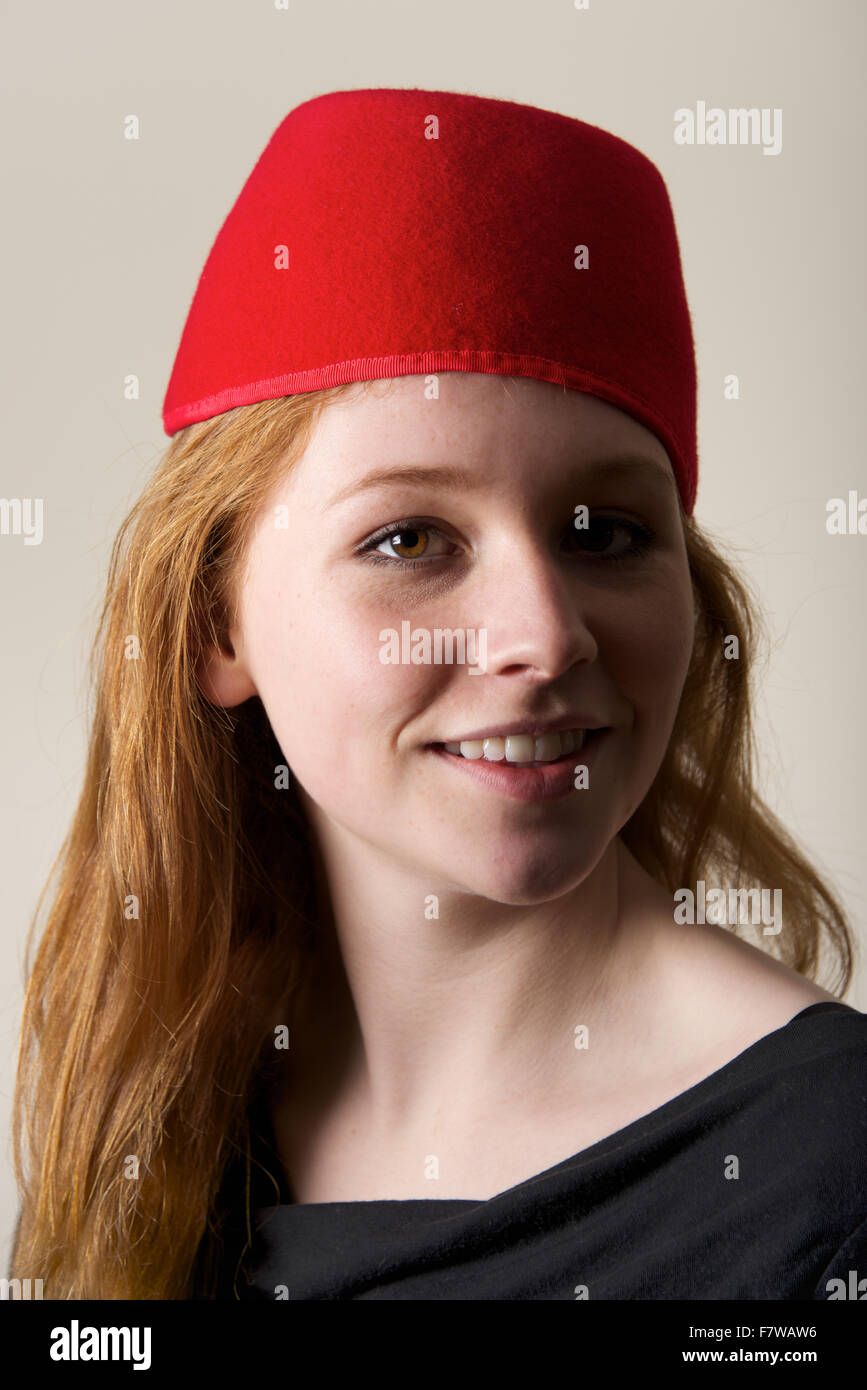 Smiling redhead in red felt Moroccan fez Stock Photo - Alamy